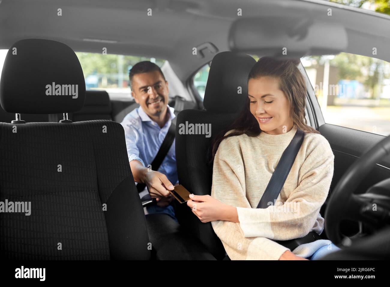 female car driver takes credit card from passenger Stock Photo - Alamy
