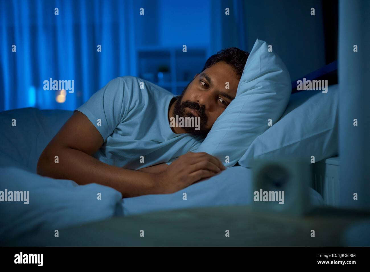 sleepless indian man lying in bed at night Stock Photo - Alamy