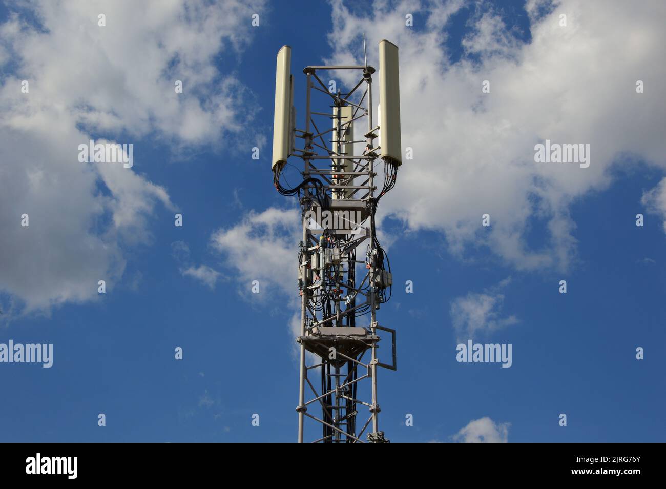 A Telecommunication antenna mast with a slightly cloudy background ...