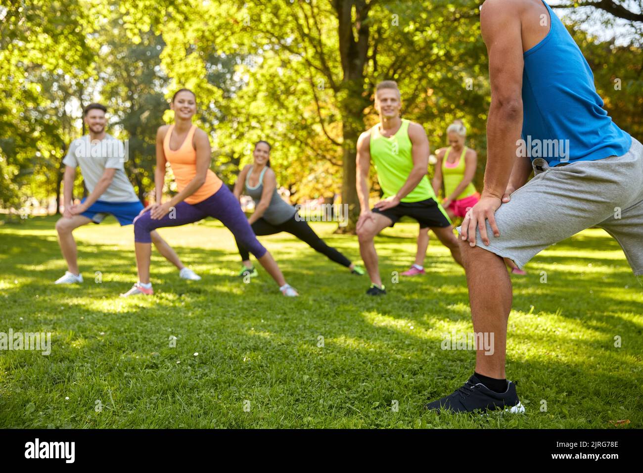 happy people exercising with trainer at park Stock Photo - Alamy