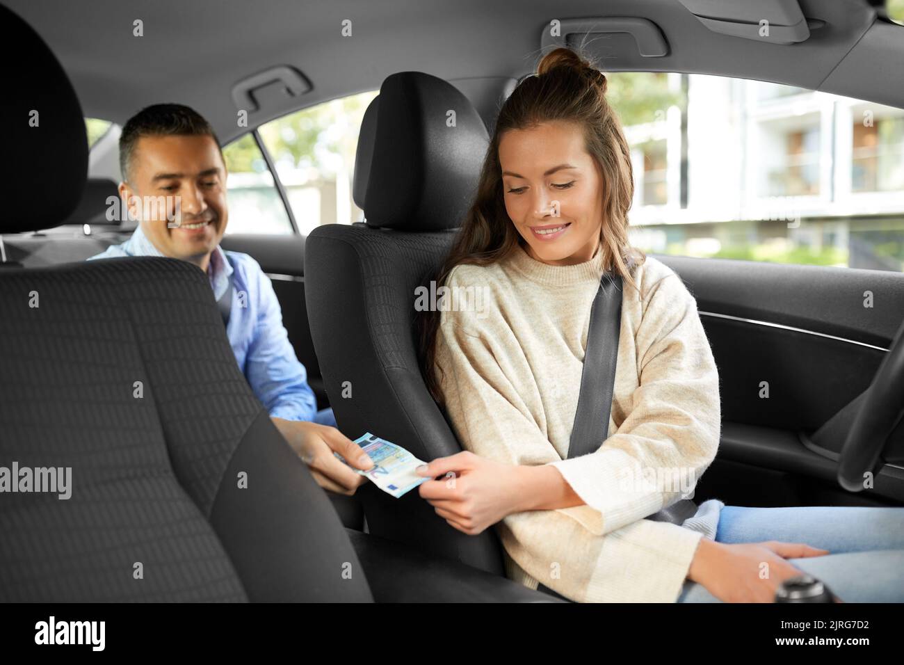 female car driver taking money from passenger Stock Photo - Alamy