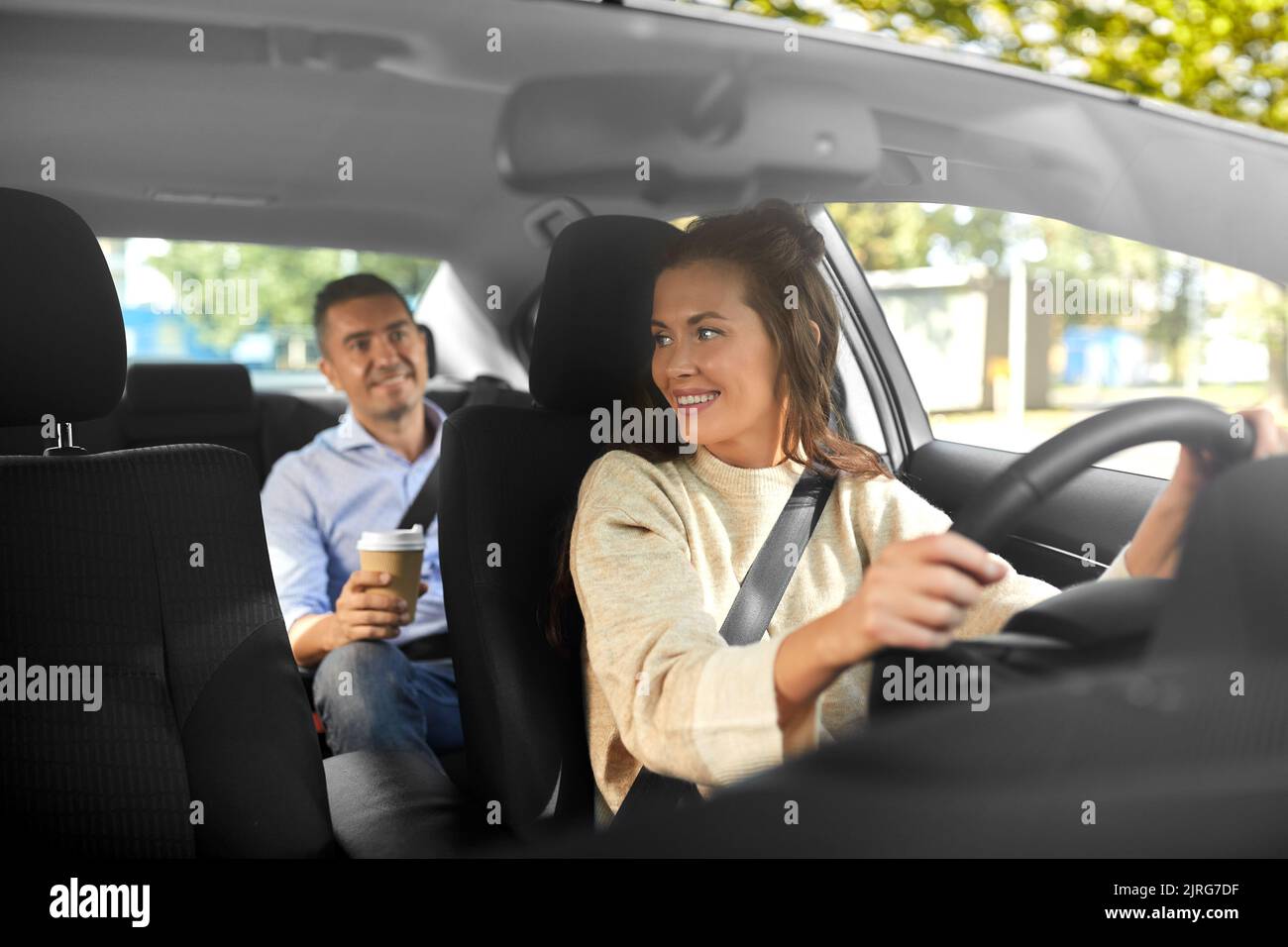female driver driving car with male passenger Stock Photo - Alamy
