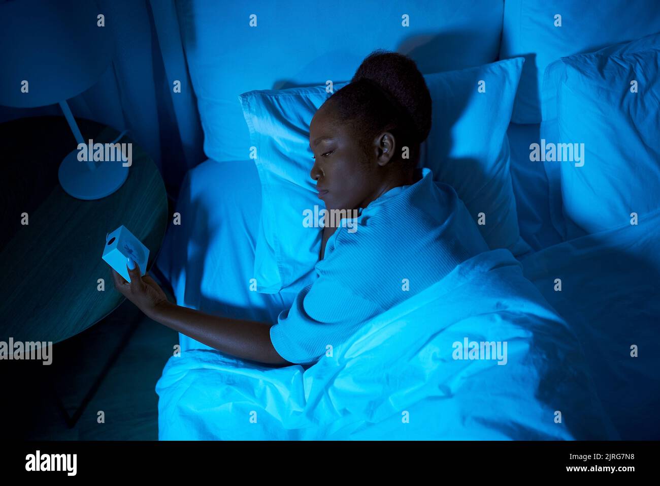woman awaking because of alarm clock at night Stock Photo - Alamy