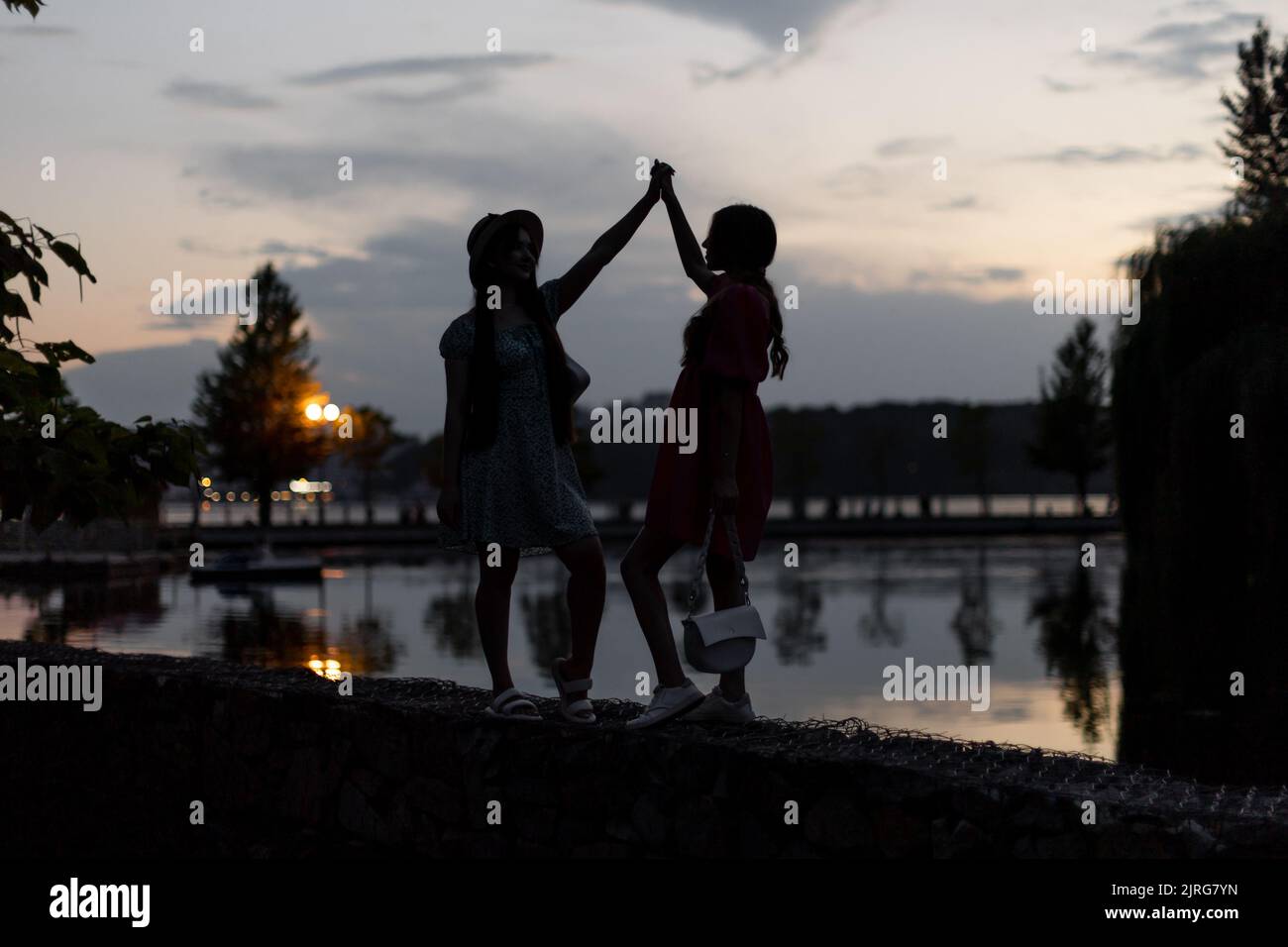 Two Teen Girls Hold Hands At Lake