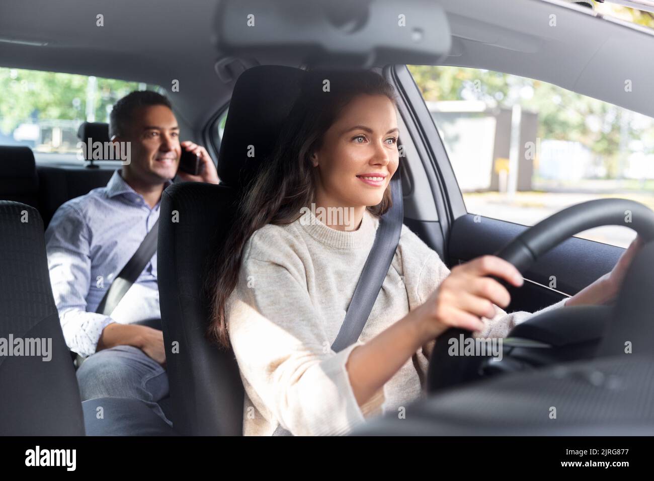female driver driving car with male passenger Stock Photo - Alamy