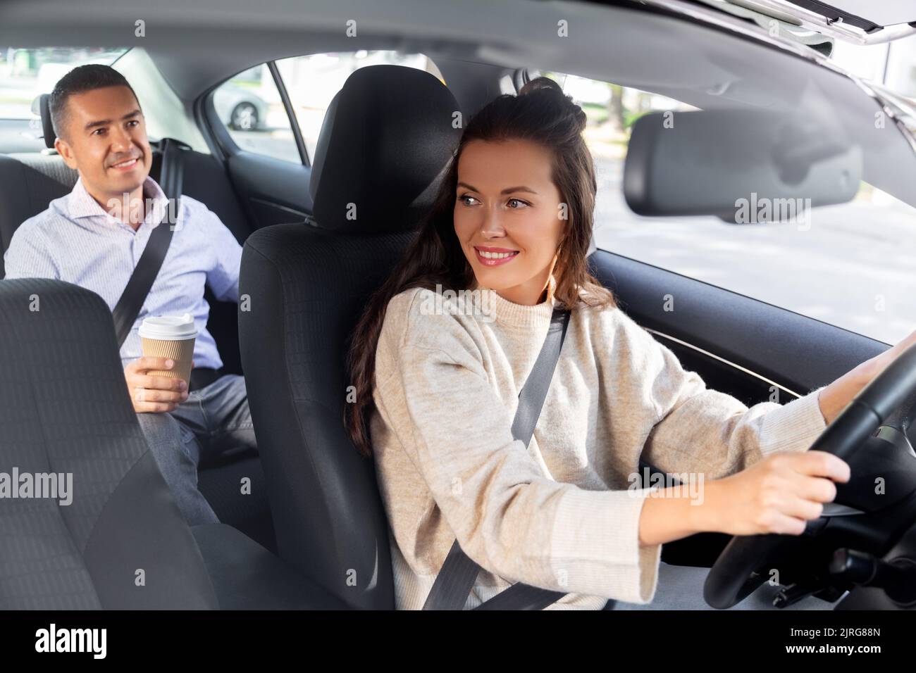 female driver driving car with male passenger Stock Photo - Alamy