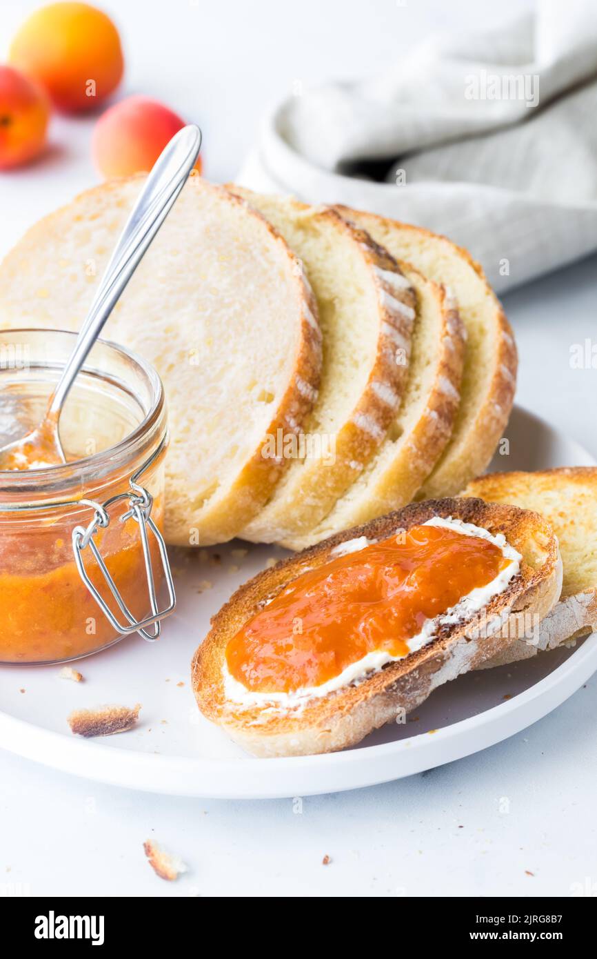 Toasted slices of bread with cream cheese and apricot spread, ready for ...