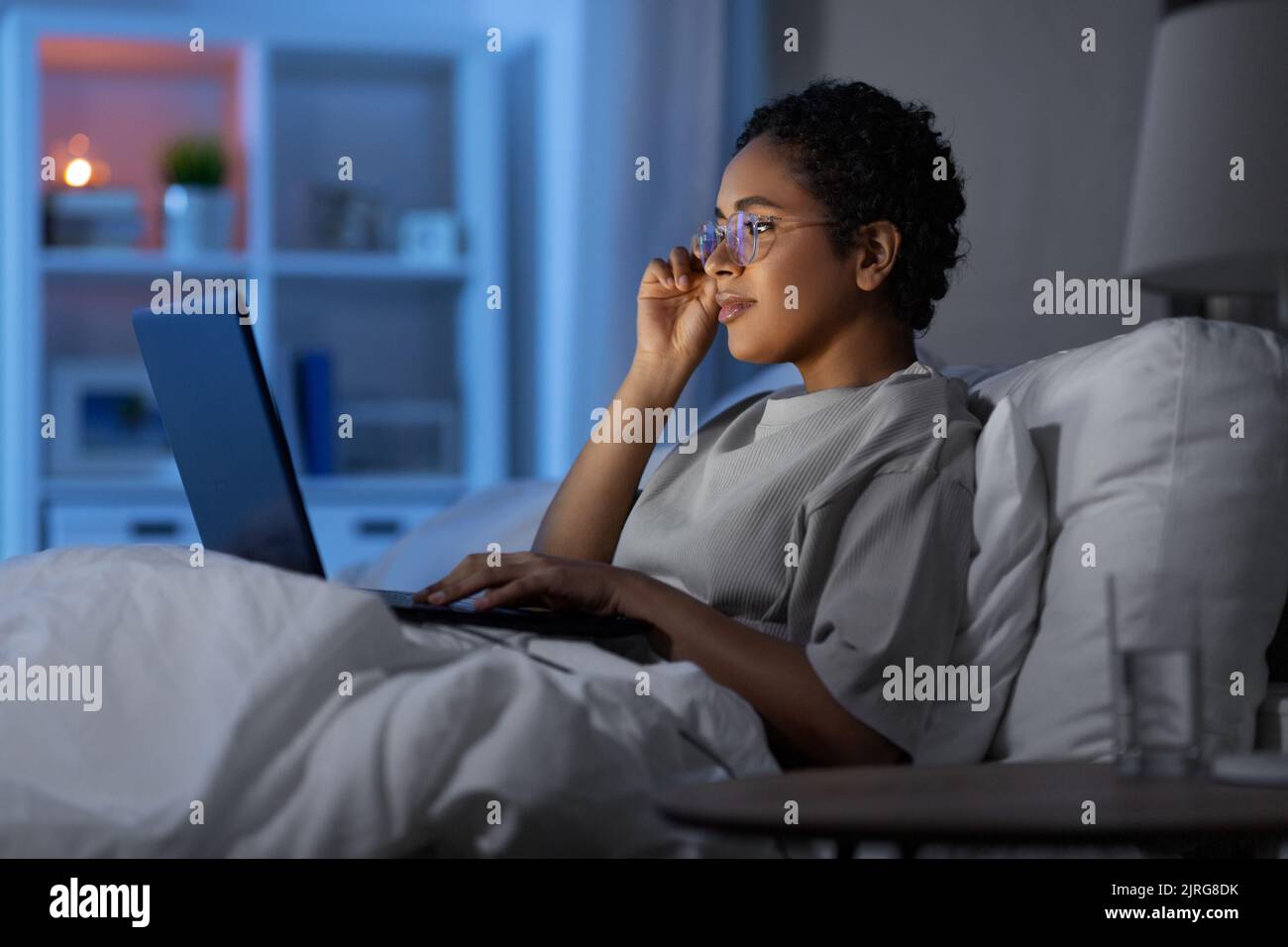 woman with laptop in bed at home at night Stock Photo - Alamy
