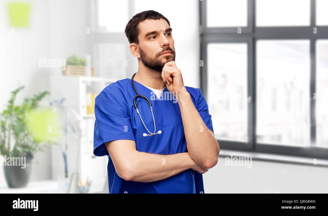 thinking doctor or male nurse with stethoscope Stock Photo - Alamy