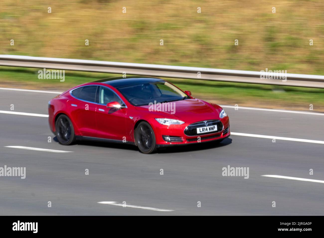 2014 red TESLA electricity; moving, being driven, in motion, travelling ...