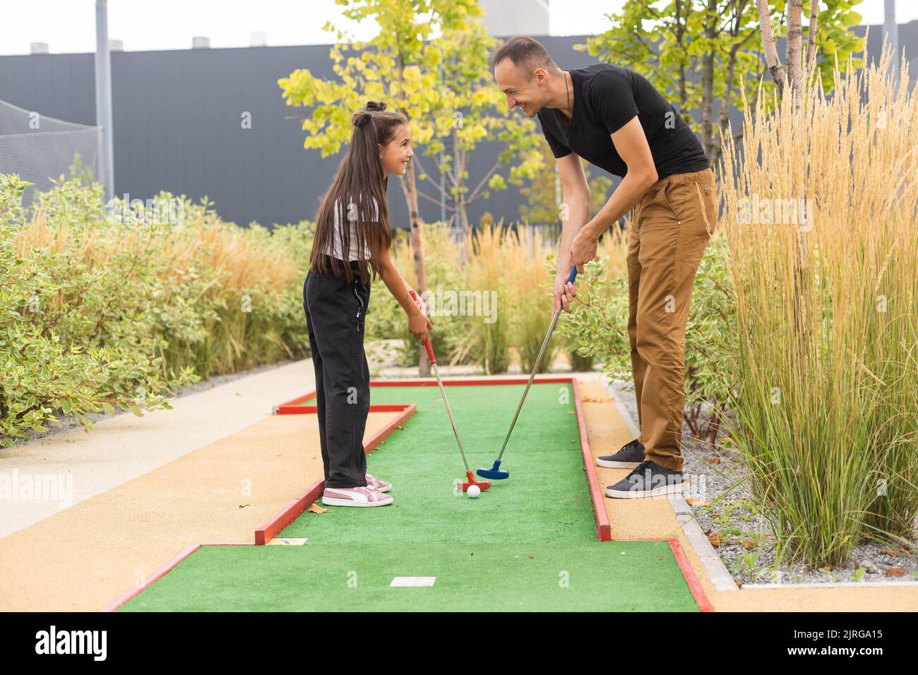father and daughter playing mini golf together in the park Stock Photo ...
