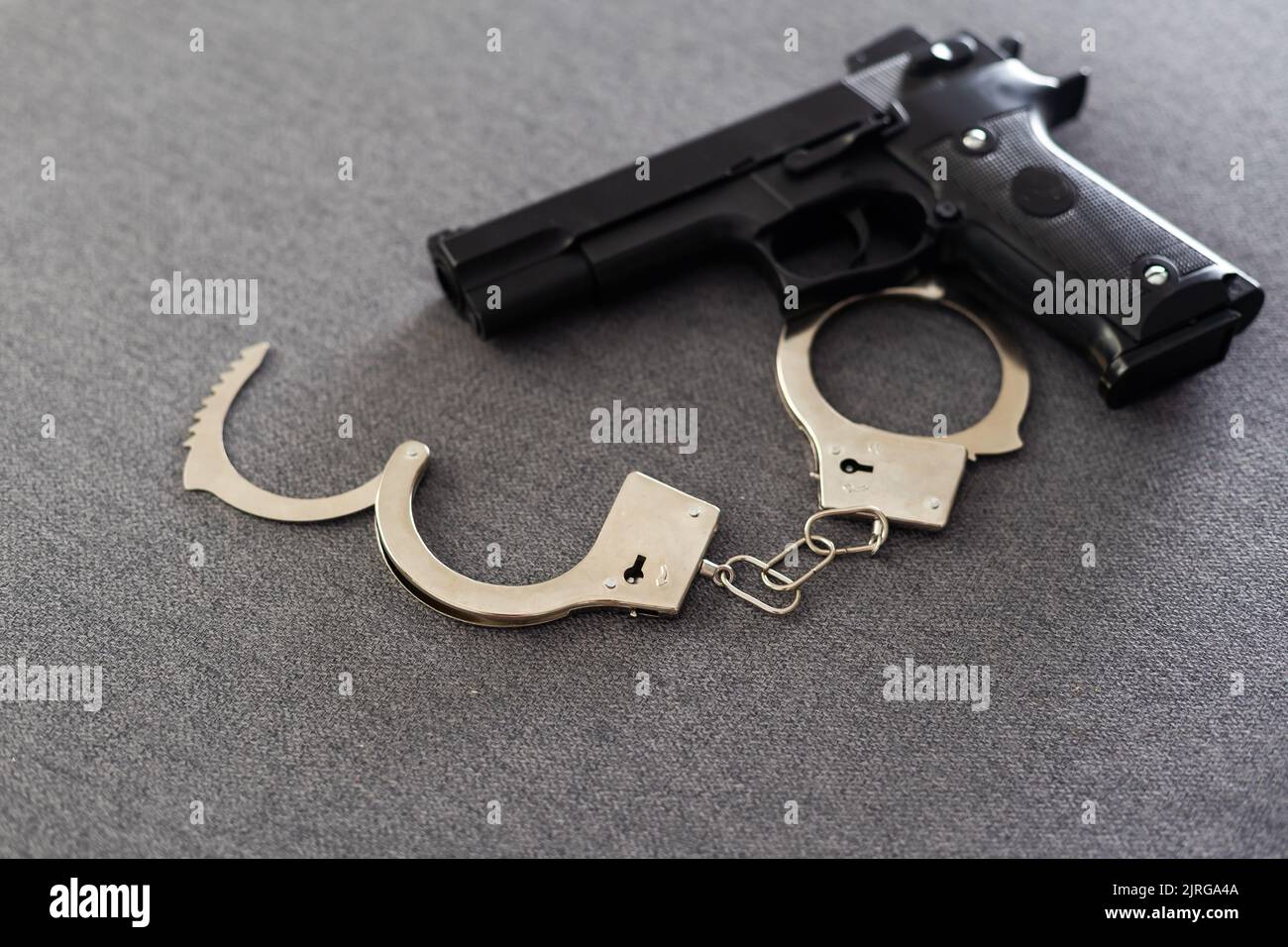 Pistol and handcuffs on black textured table. Ammunition of law ...