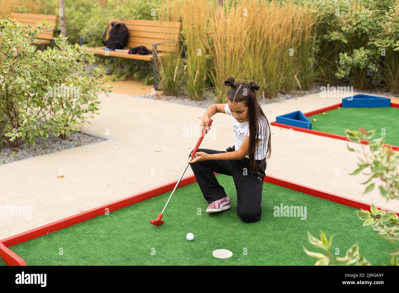Cute little girl playing mini golf in a park Stock Photo - Alamy