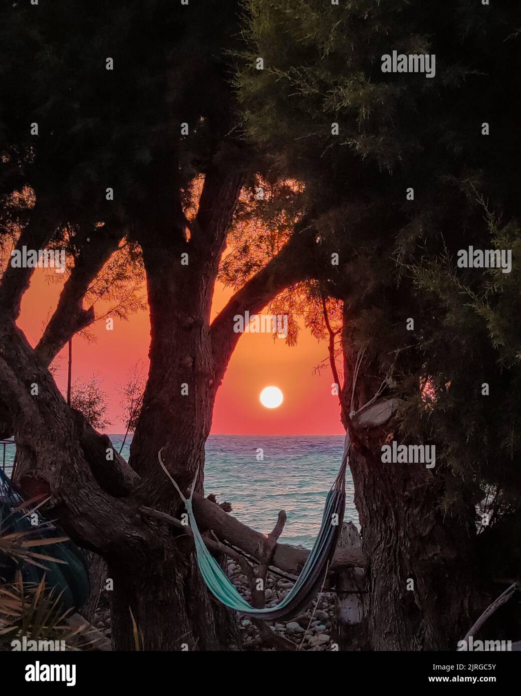 Seascape view with hammock and beautiful sunset in Rhodes, Greece. High ...