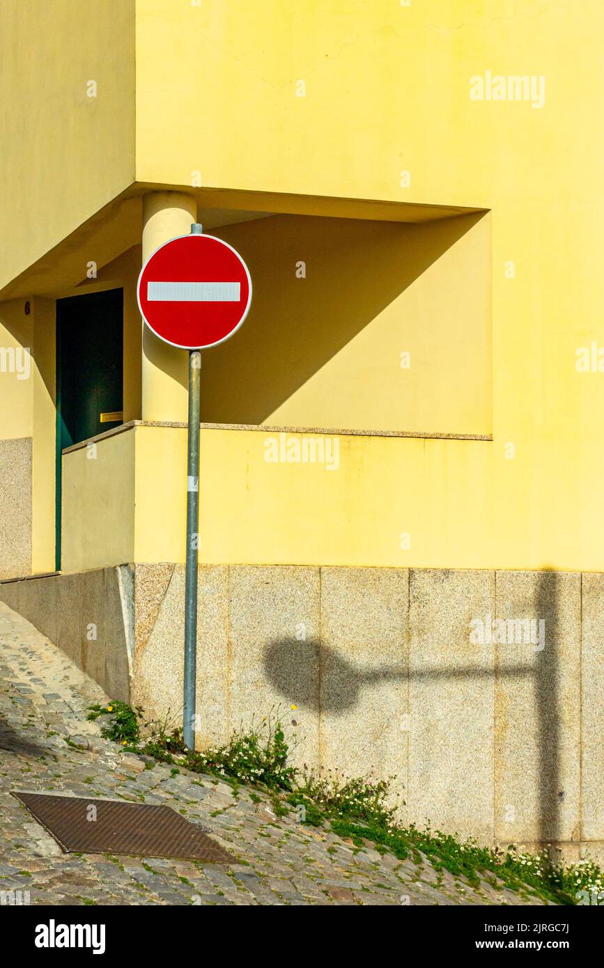 No entry sign in front of a yellow painted concrete building in a city ...