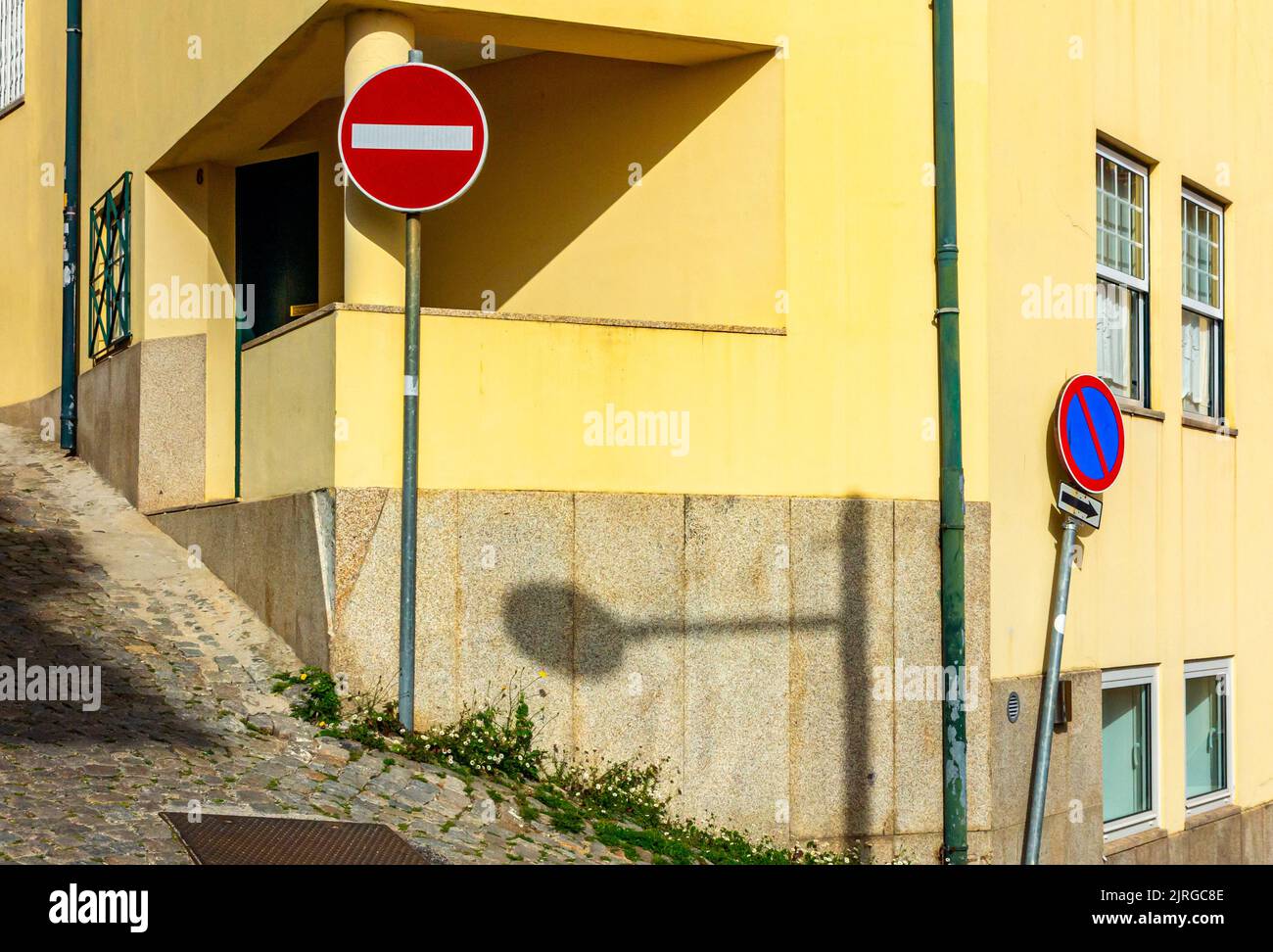 No entry sign in front of a yellow painted concrete building in a city ...