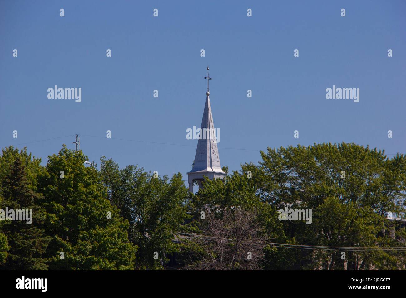 Historic parish church spire behind trees Stock Photo - Alamy