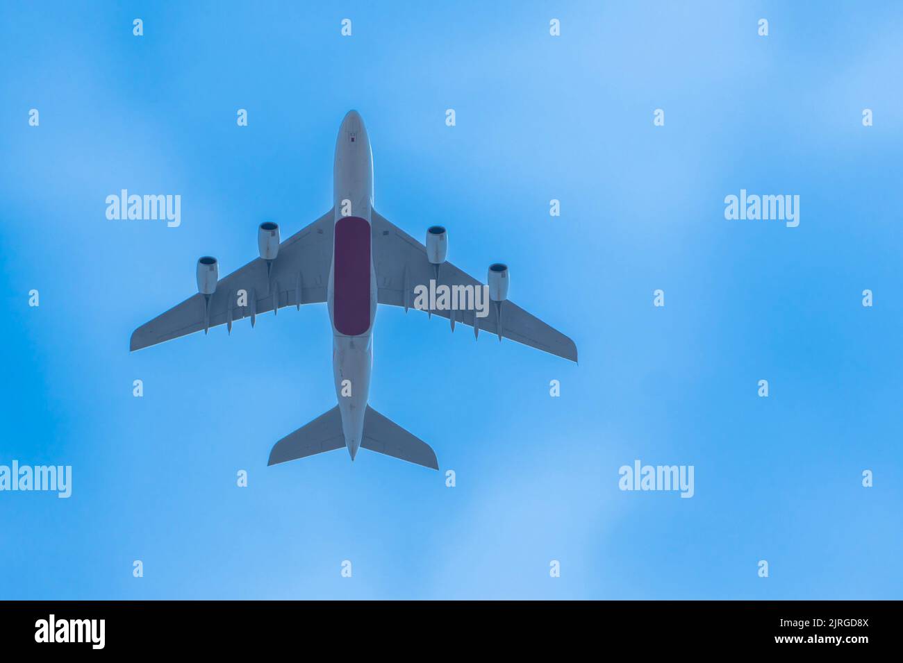 Airbus A380 super jumbo flying over head through blue skies Stock Photo ...