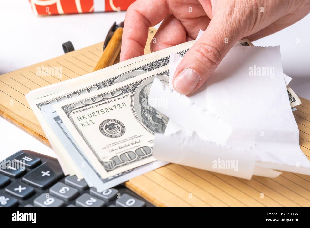 A woman's hand holding an empty check and money dollars, counting cash ...
