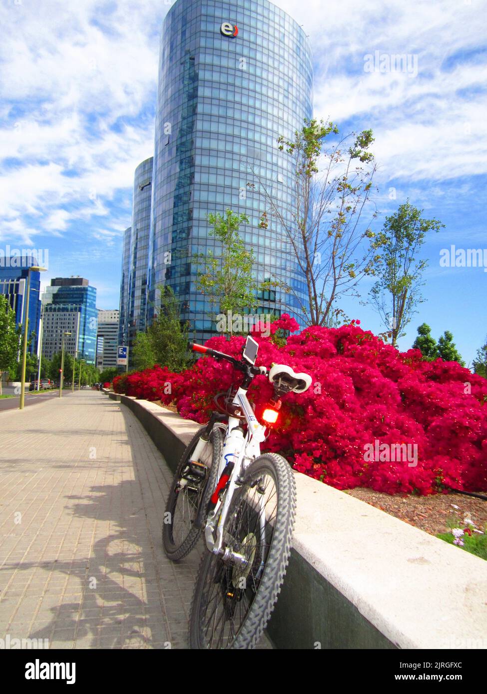 A vertical closeup of a bicycle leaning on the curb against the red ...
