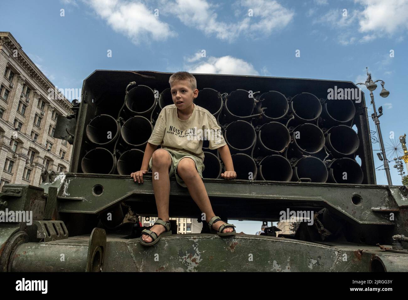 A young boy poses for a photo with the display of a destroyed Russian ...