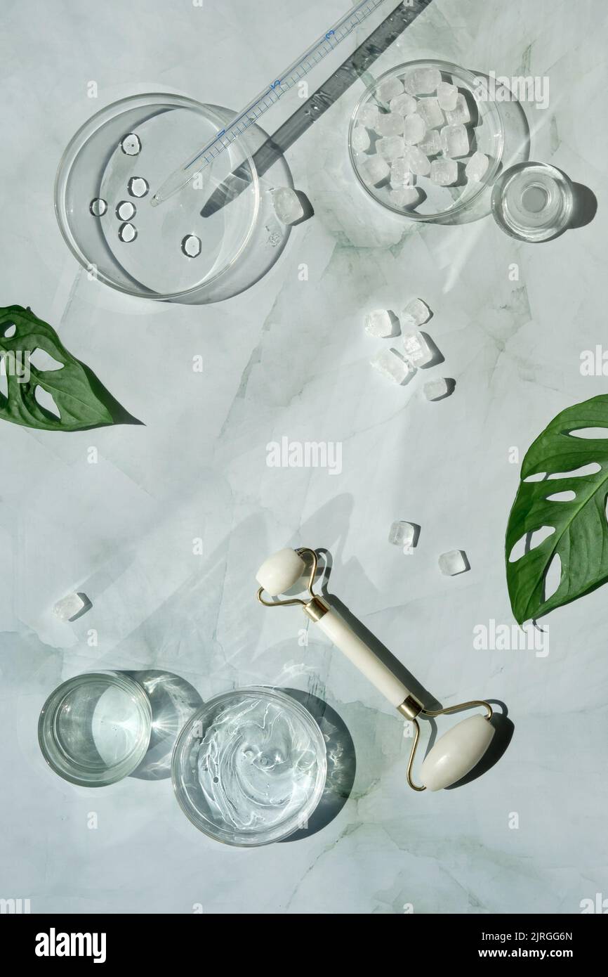 Home made moisturizer and green jade stone face roller on off white ...