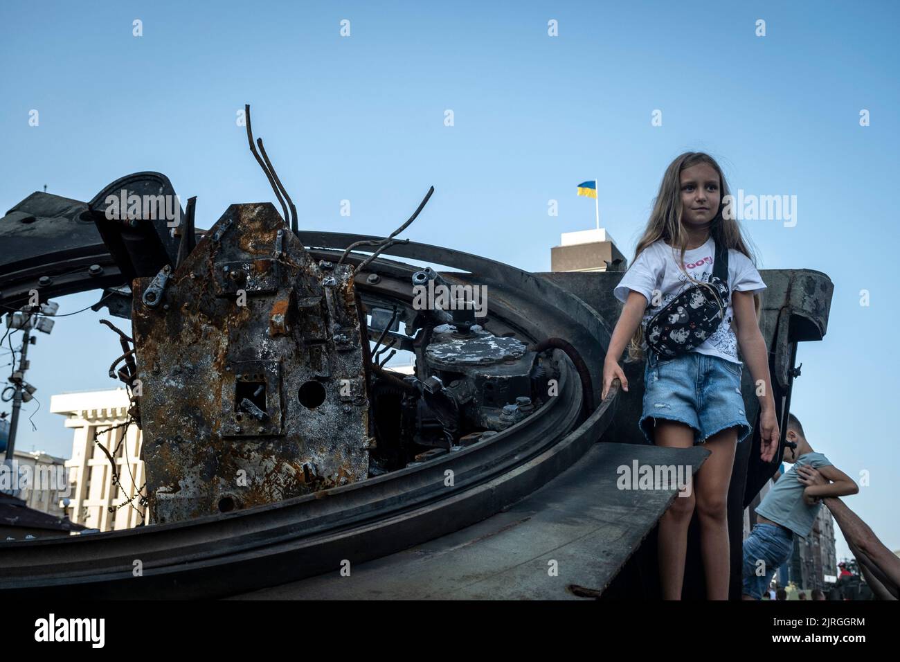 A young girl poses with the wreckage of a destroyed Russian tank on the ...