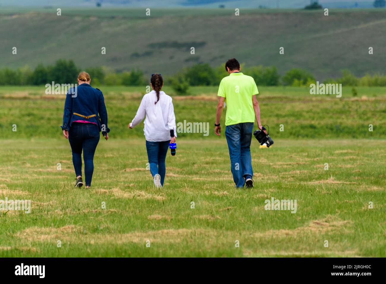A Television crew walking in a green field Stock Photo - Alamy