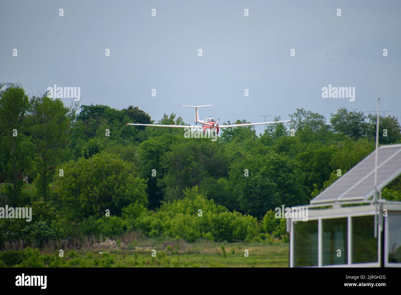 An airplane flying over trees for the show at Hangariada aeronautical ...
