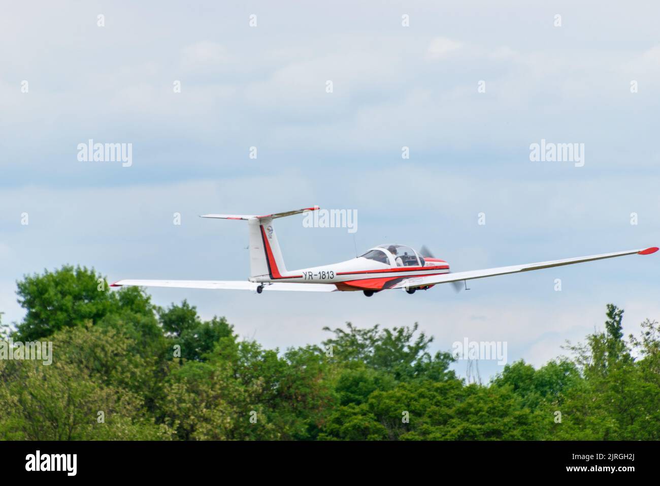 An airplane flying over trees in the show at Hangariada aeronautical ...