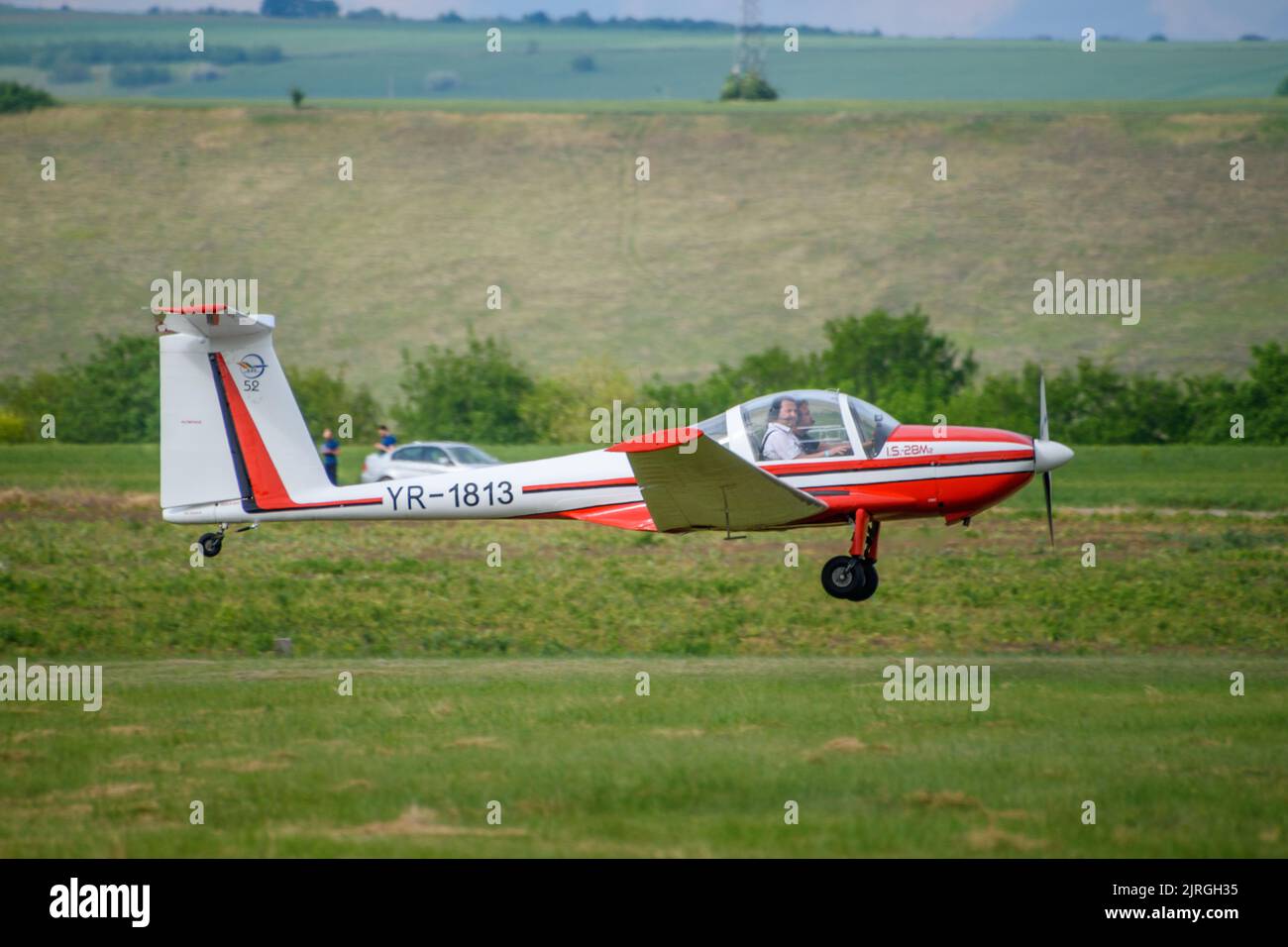 An airplane flying over a greenery landscape at Hangariada aeronautical ...