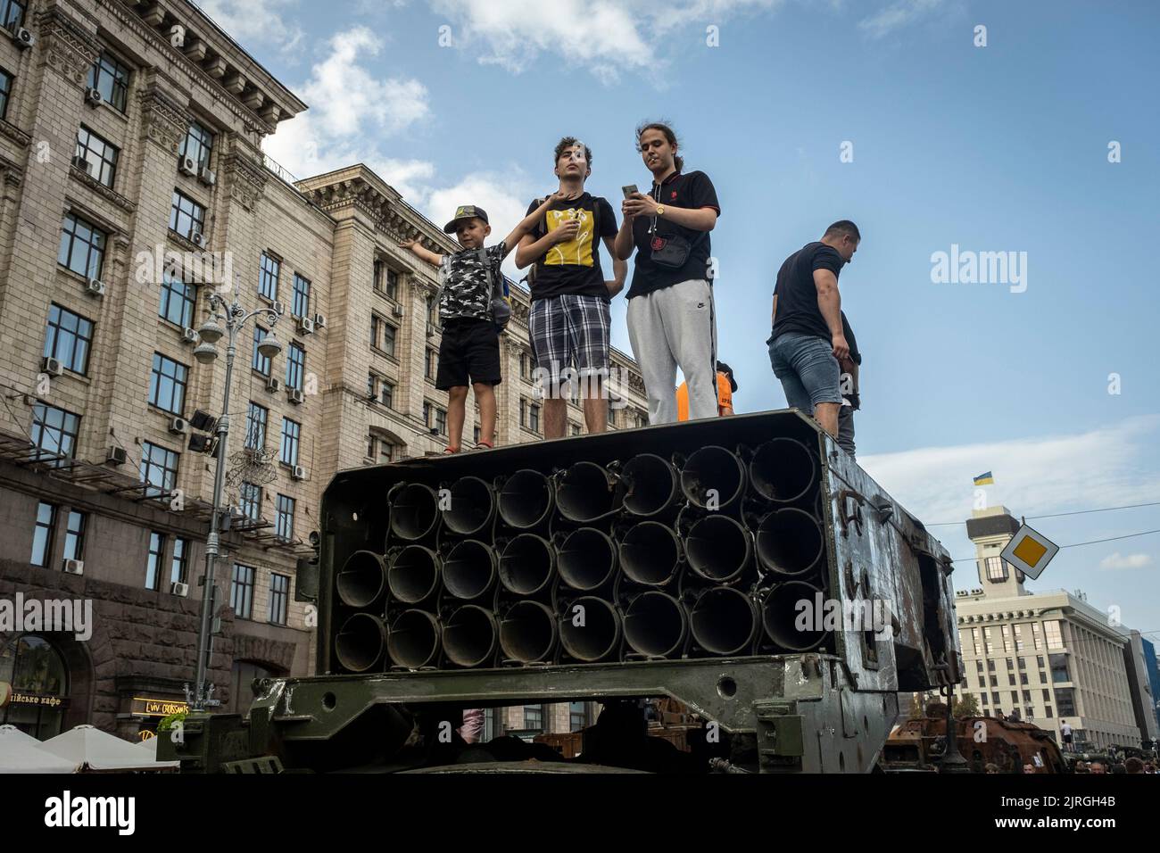 Children and teenagers stand on top of the display of a destroyed ...