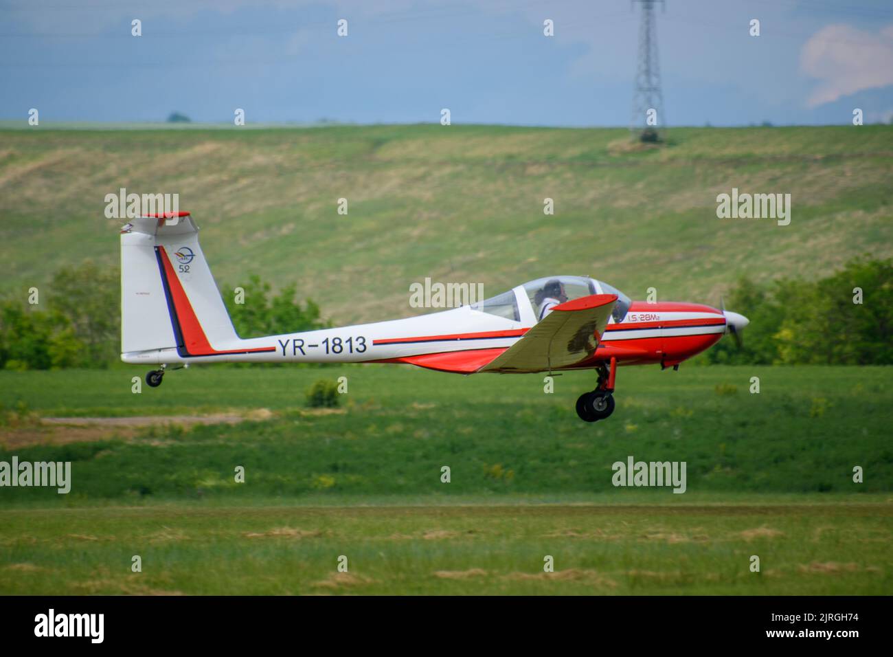 An airplane flying over a greenery landscape at Hangariada aeronautical ...