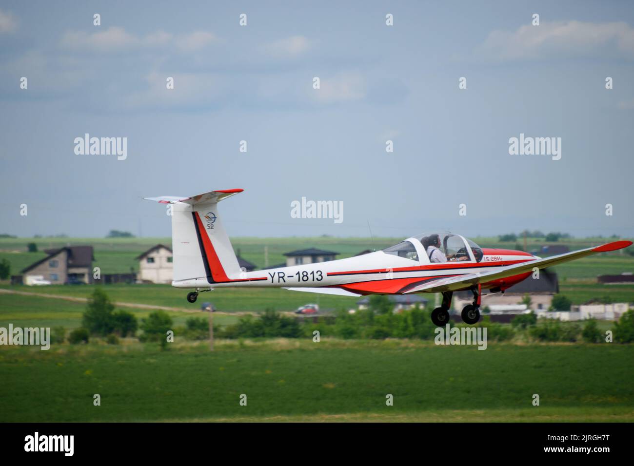 An airplane flying over a greenery landscape at Hangariada aeronautical ...