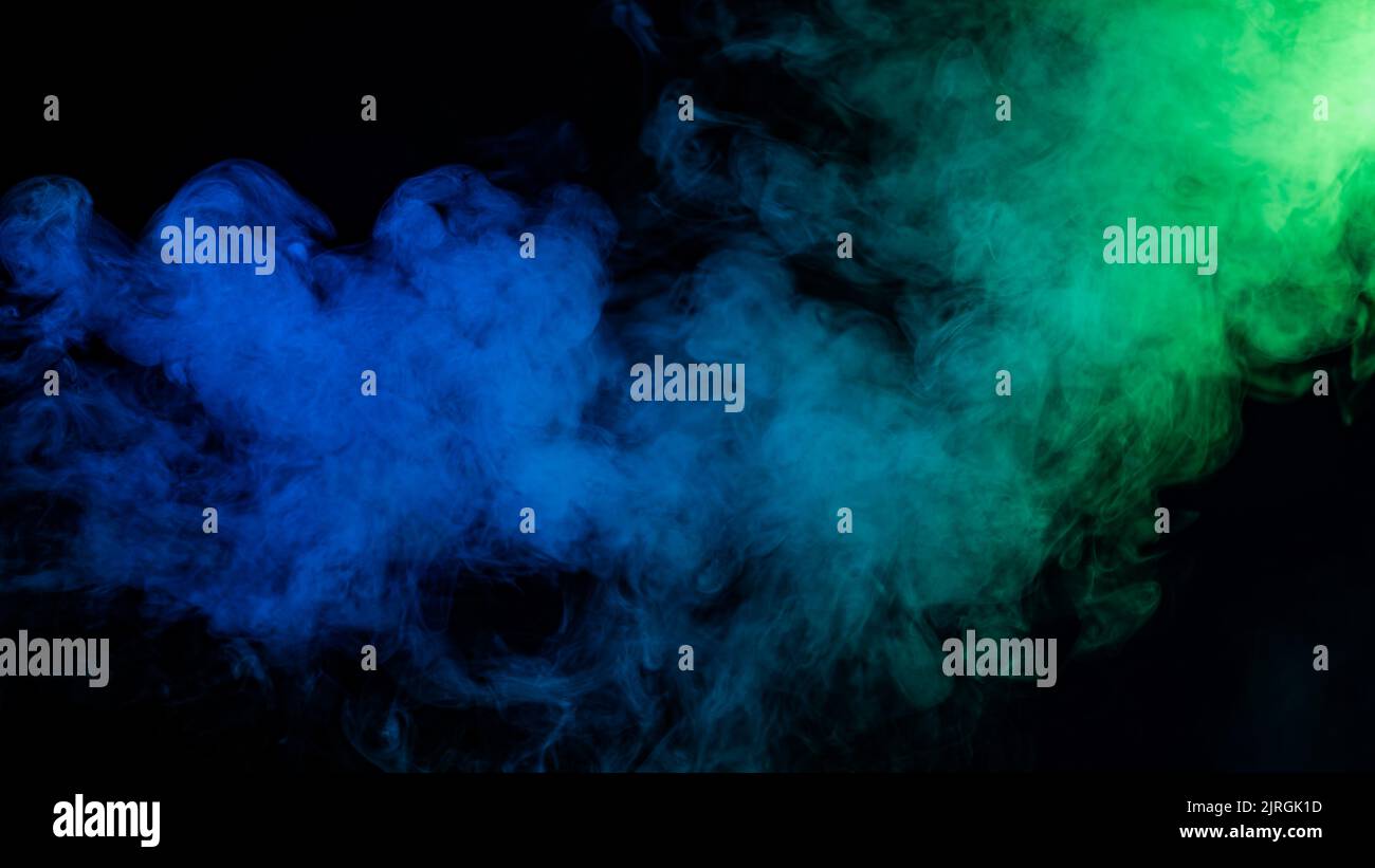 Green-blue smoke in neon light on black background Stock Photo - Alamy