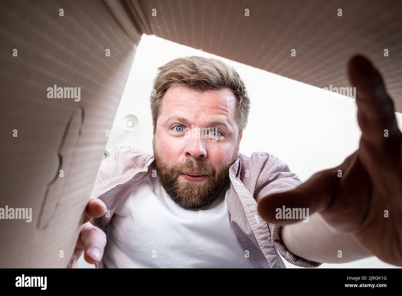 Satisfied man holds out his hand, trying to get a gift or parcel from ...