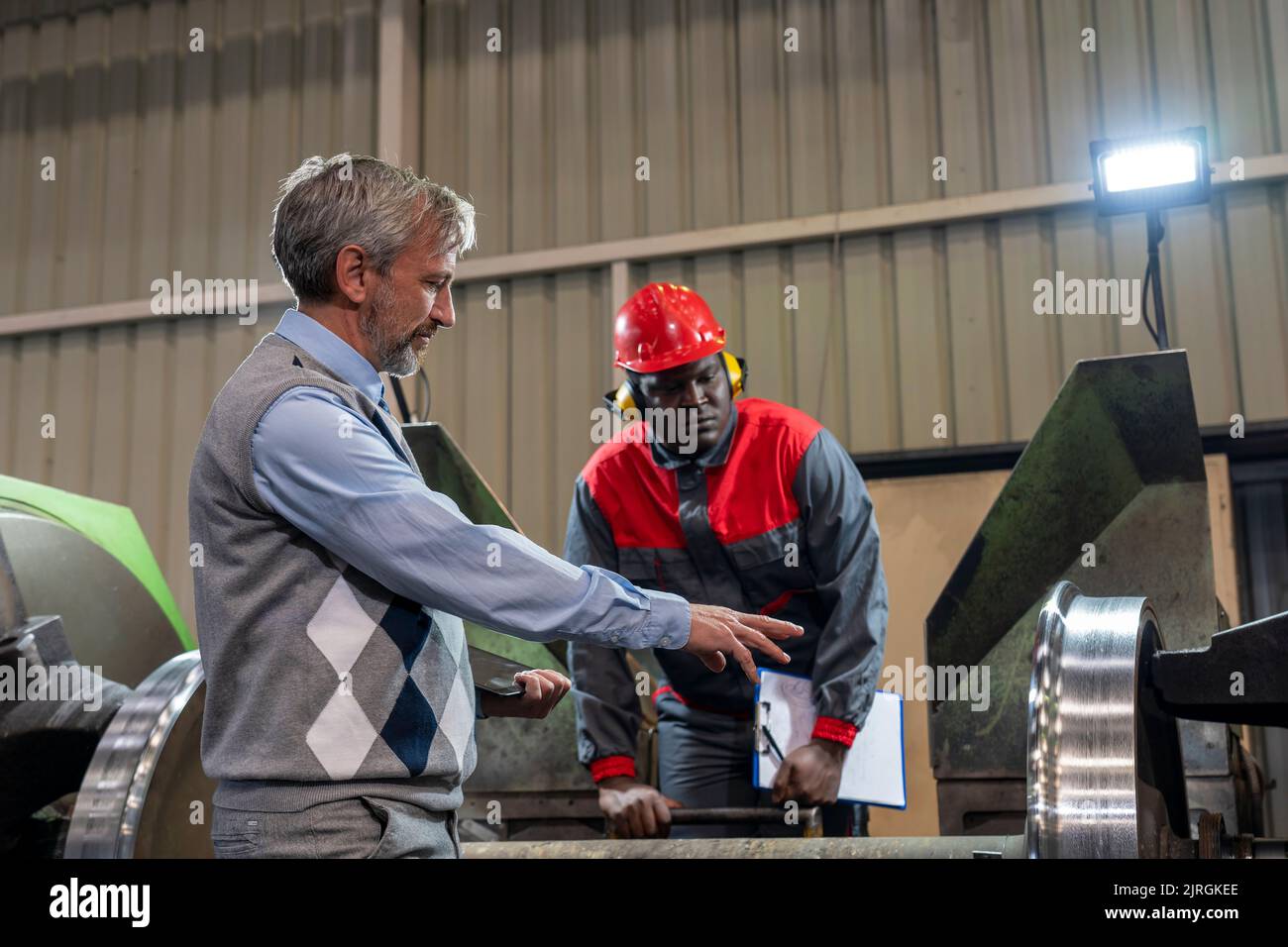 Quality Control Inspector Talking To African American CNC Operator Next ...