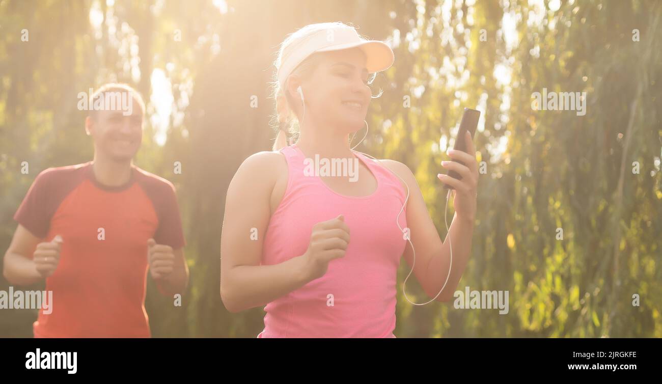 Fitness sporty woman runner in rural nature listening to music Stock ...