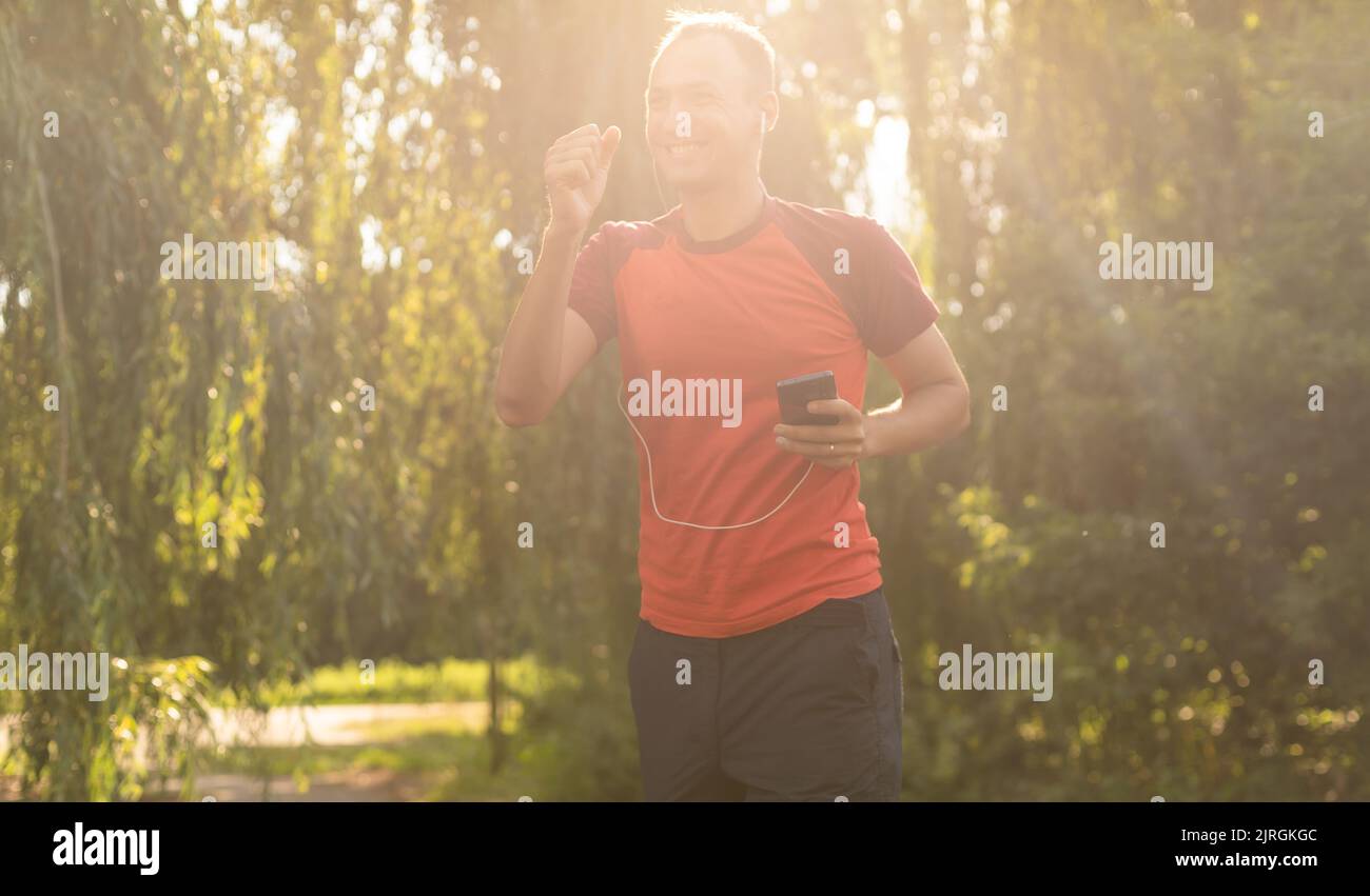 Portrait of a man running in a park. Close up of a smiling man running ...