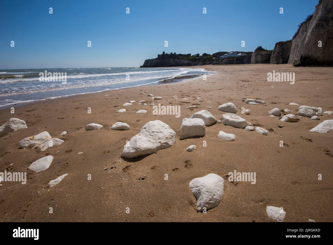 Large chunks of white chalk fallen from the cliff lie in the sand at ...