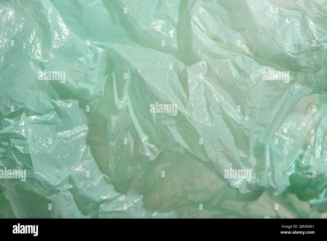 Green plastic background, wrinkled single use bag. Concepts ...