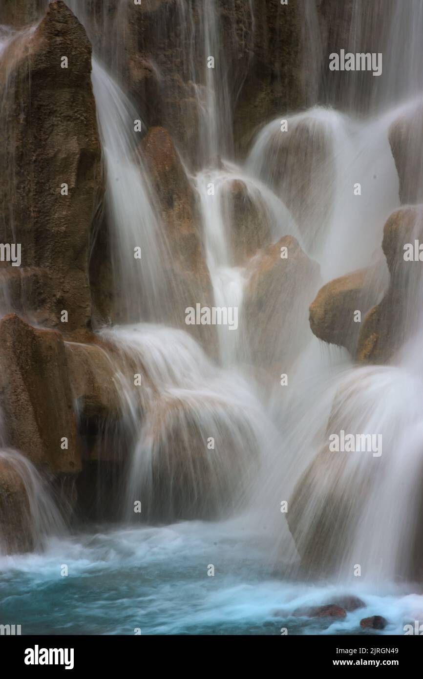 A raging waterfalls surrounded by rocks Stock Photo - Alamy