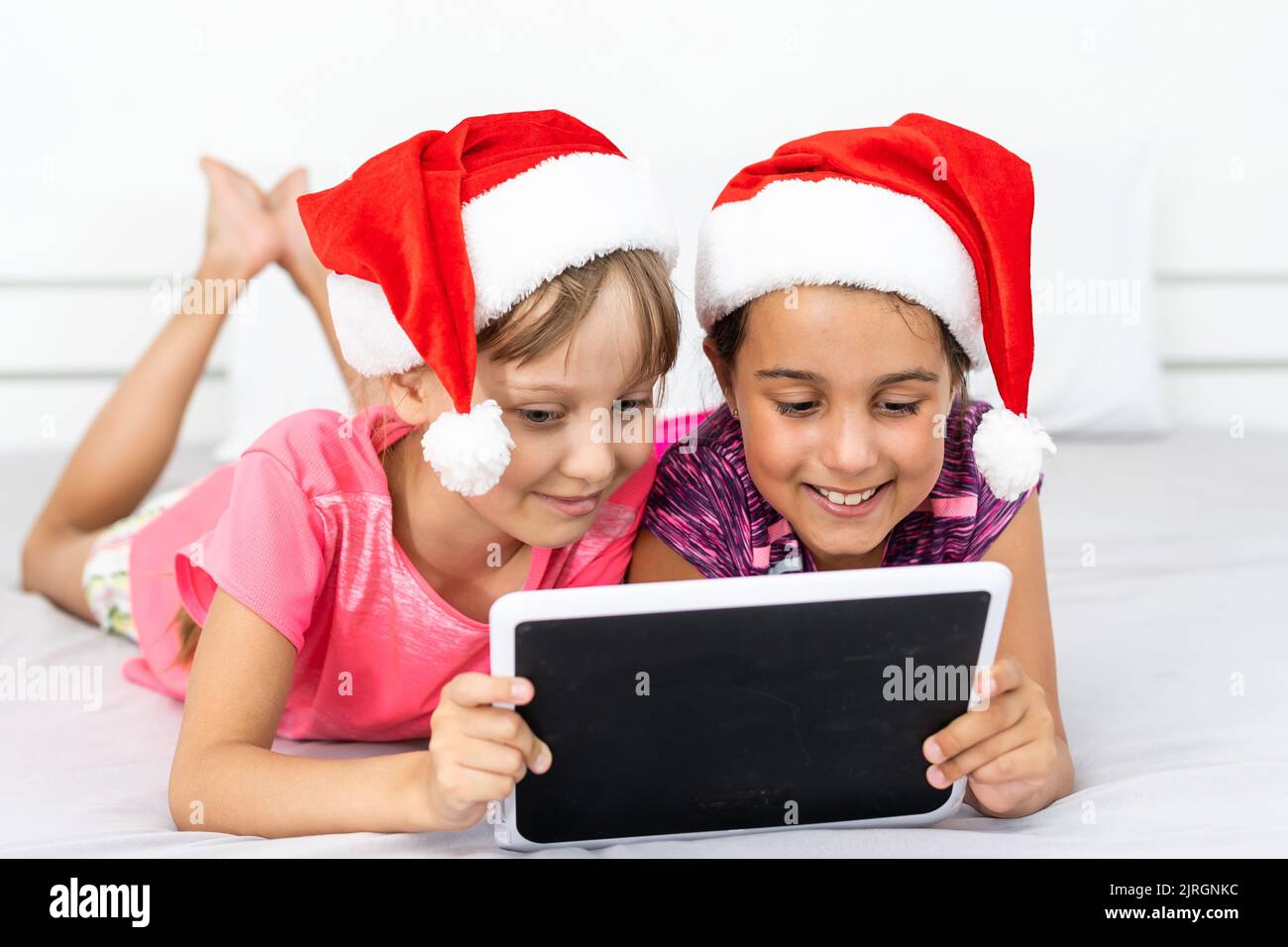 Excited small sister kids have fun browsing playing on modern tablet ...