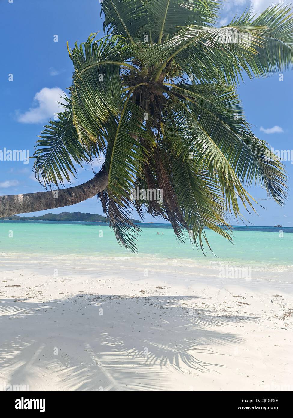 A sunny day on the beach with a cloudy blue sky Stock Photo - Alamy