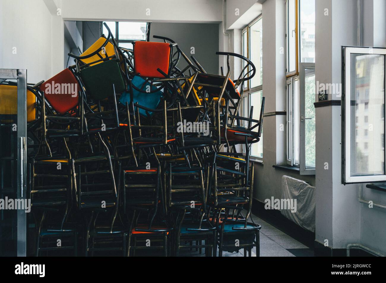 A huge stack of colorful chairs in school corridor Stock Photo - Alamy