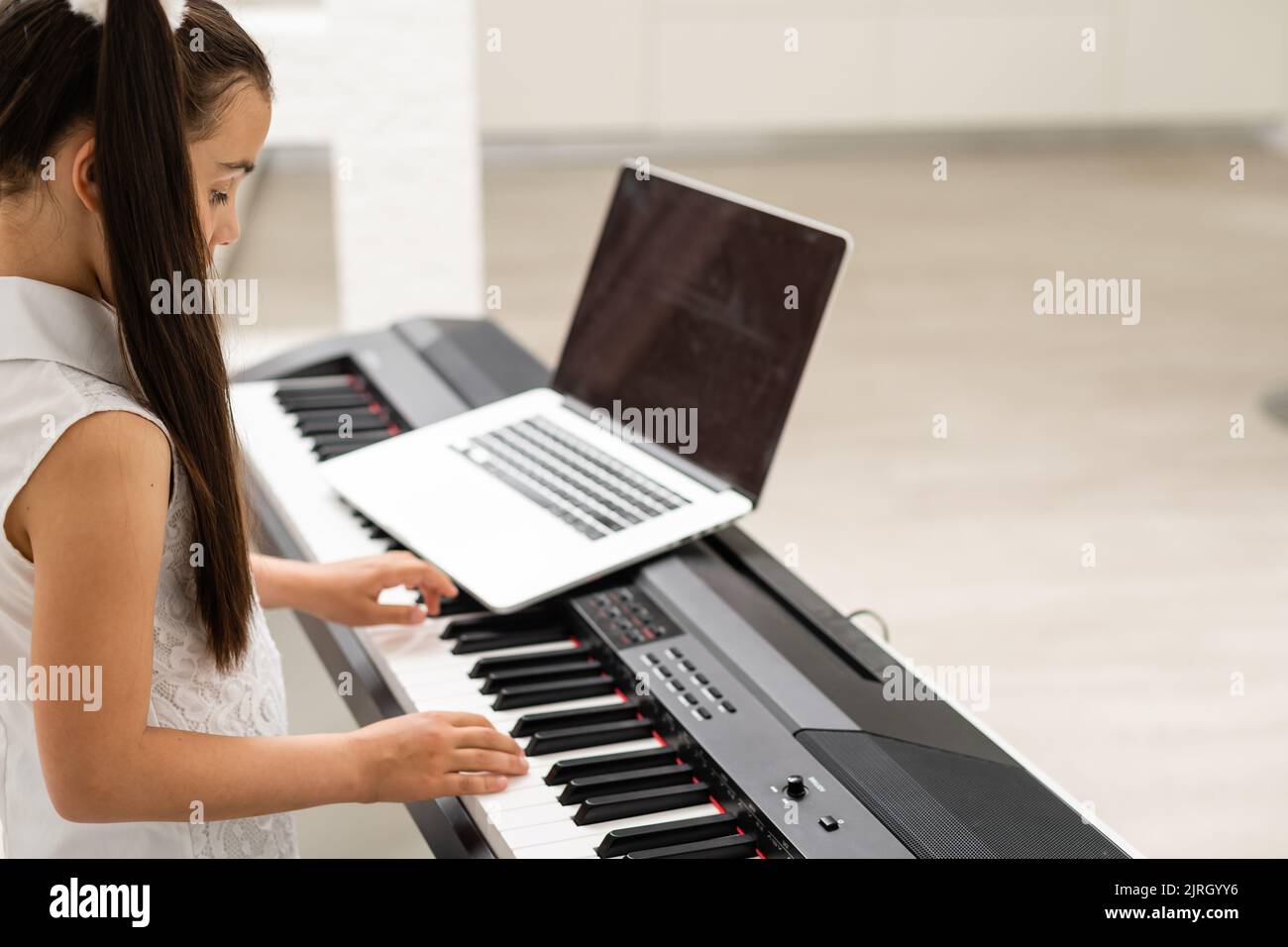 Homeschool little young kid girl learning piano from computer ...