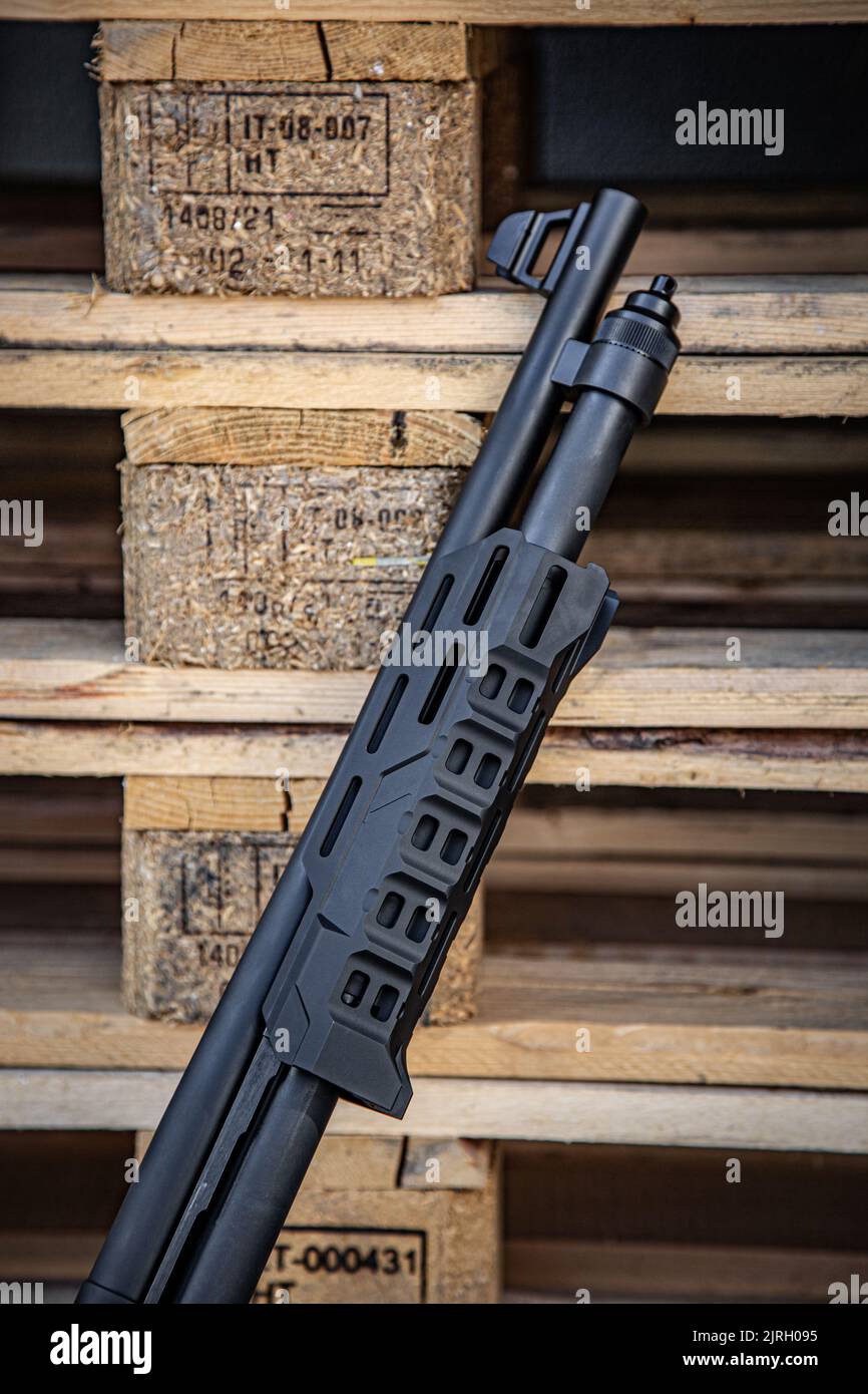 Pump-action 12 gauge shotgun. A smooth-bore weapon. Wooden background ...