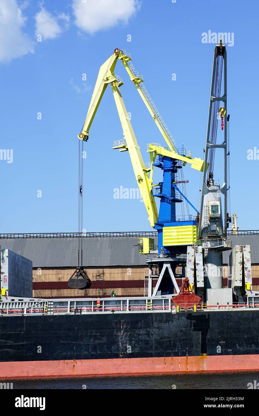 Port crane with bulk cargo bucket painted in the colors of the ...