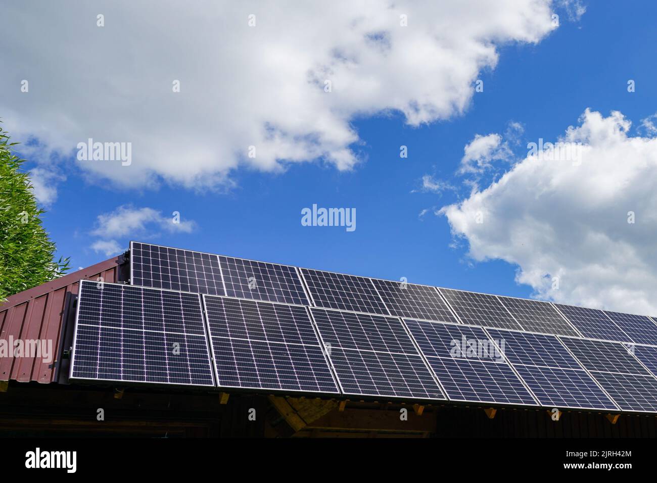Many photovoltaic solar panels mounted on wooden house roof, background ...