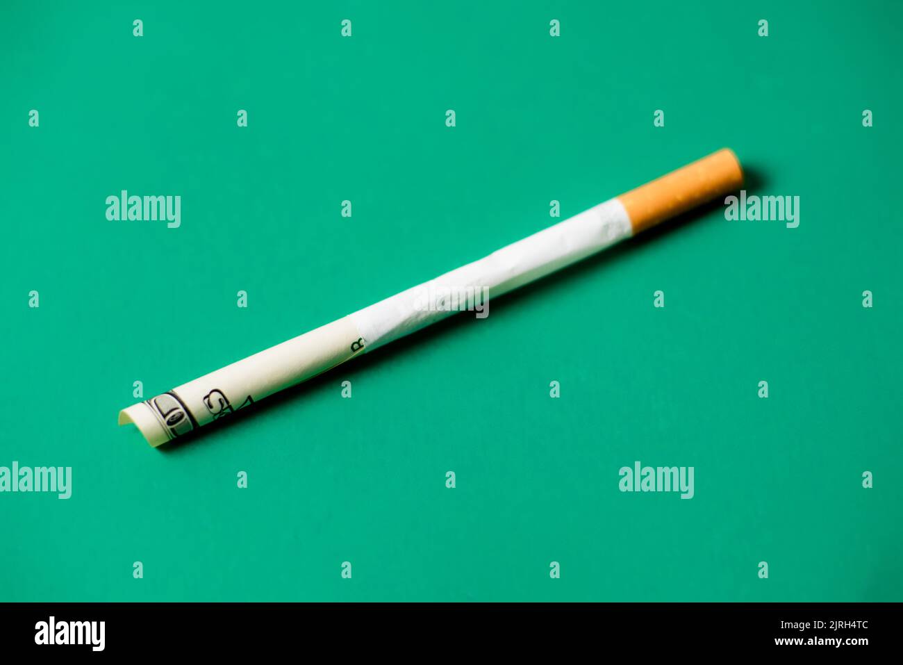 Smoking and money. Rolled up dollar bill in a cigarette. Green ...